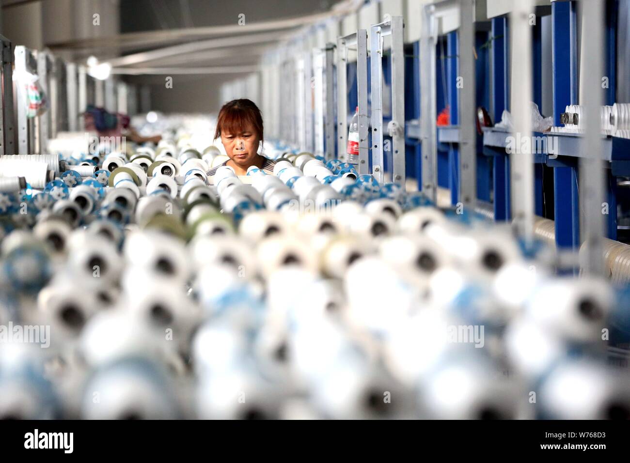 --FILE--A female Chinese worker handles production of yarn at a textile factory in Huaian city ...