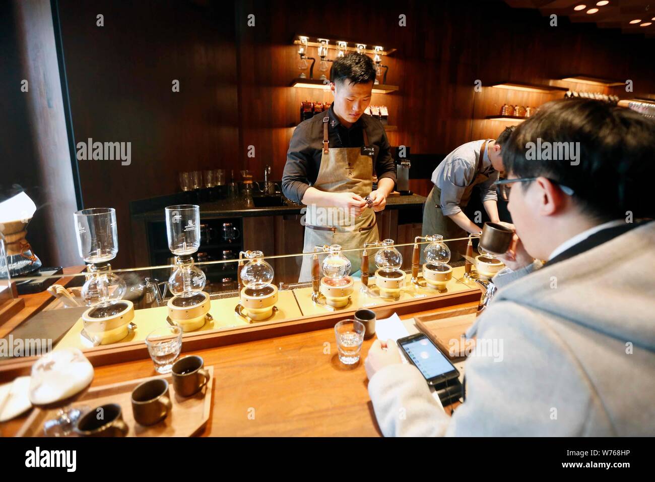 Baristas prepare coffee for customers at a coffee bar of the world's ...