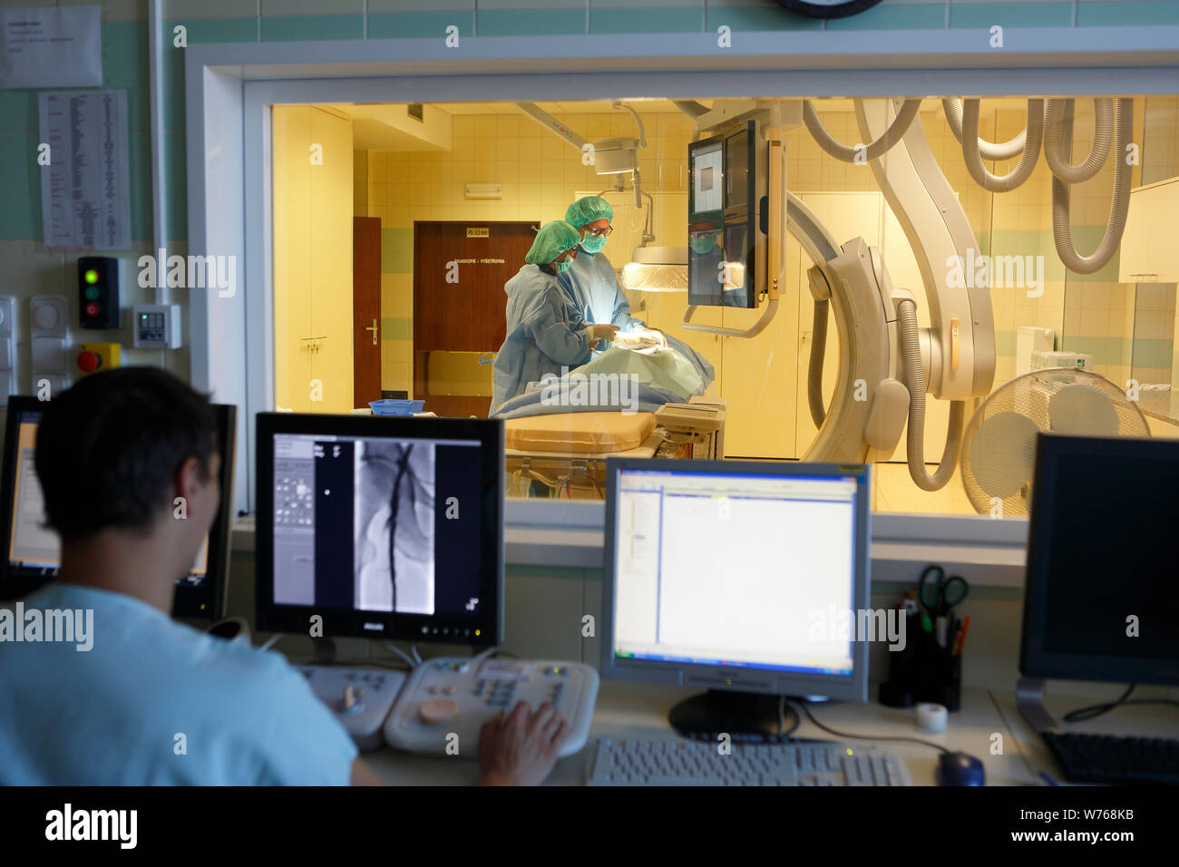 Interventional radiology, doctor monitors the work of colleagues on the ...