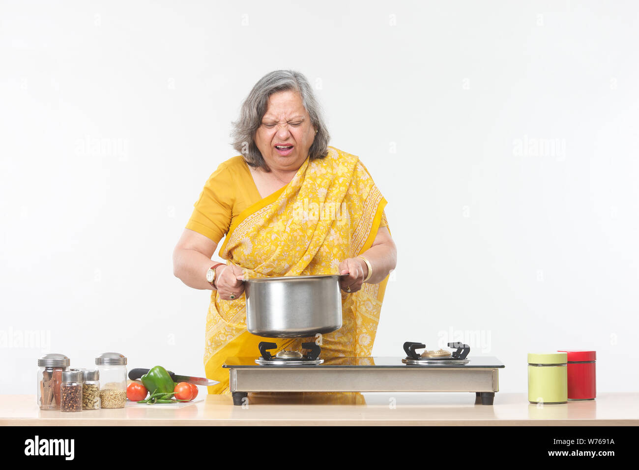 Old woman suffering from pain while cooking food in kitchen Stock Photo ...