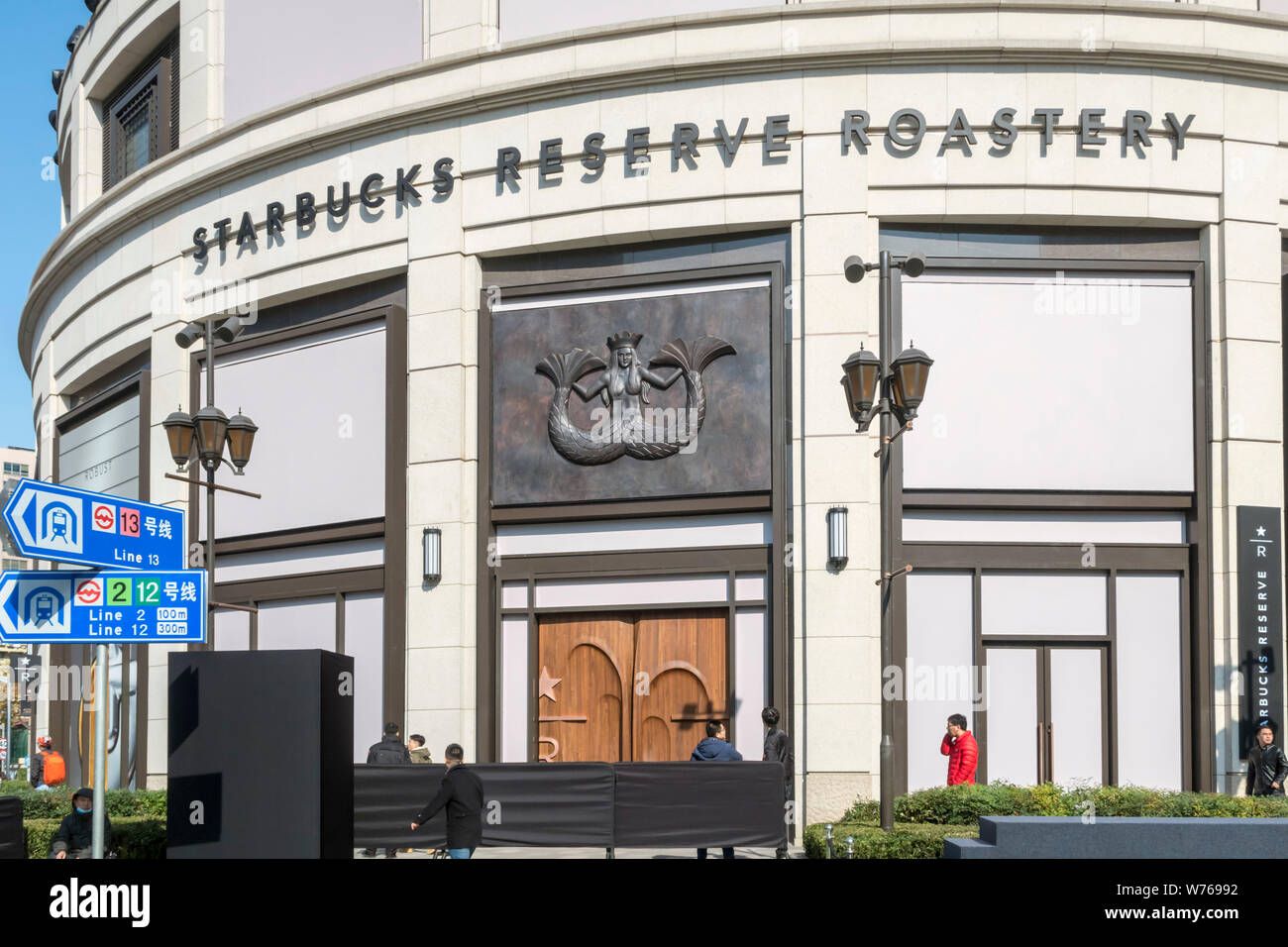 Chinese pedestrians walk past the world's largest Starbucks Reserve ...