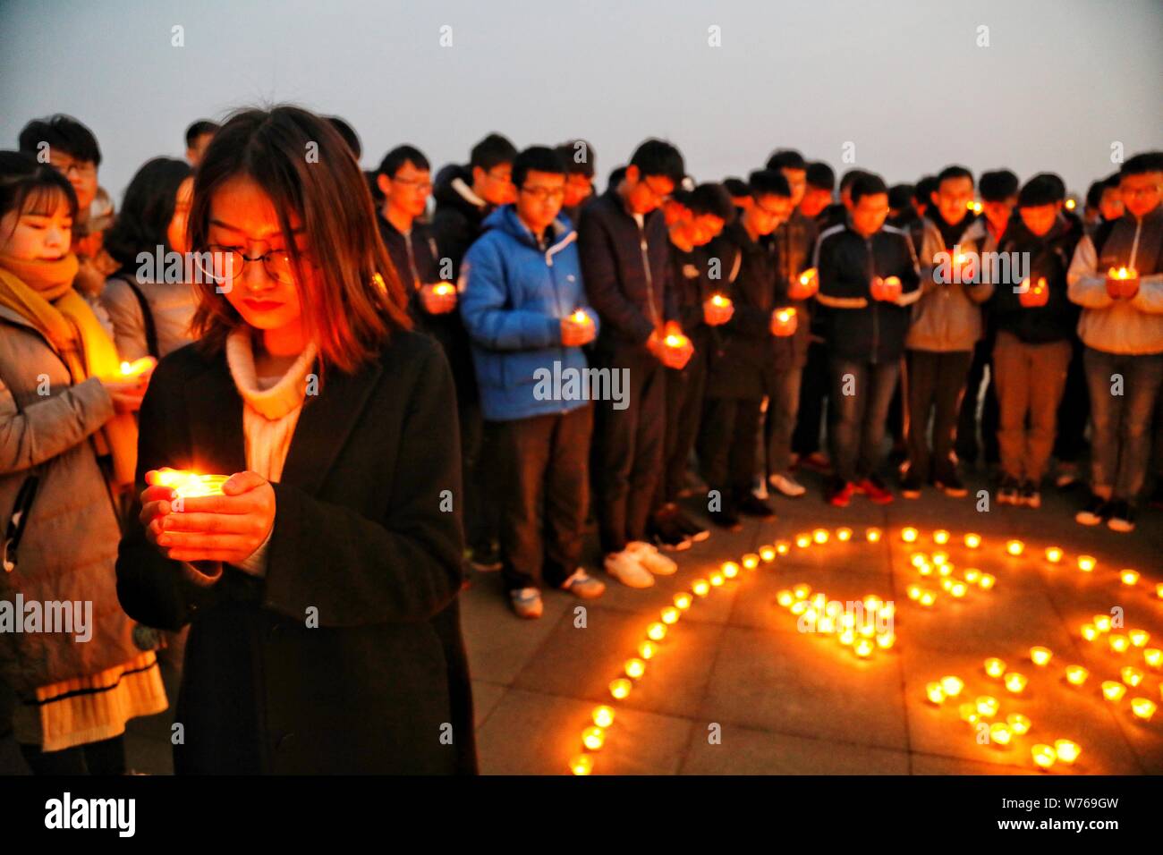Chinese students hold candles during a candlelight vigil to mourn the ...