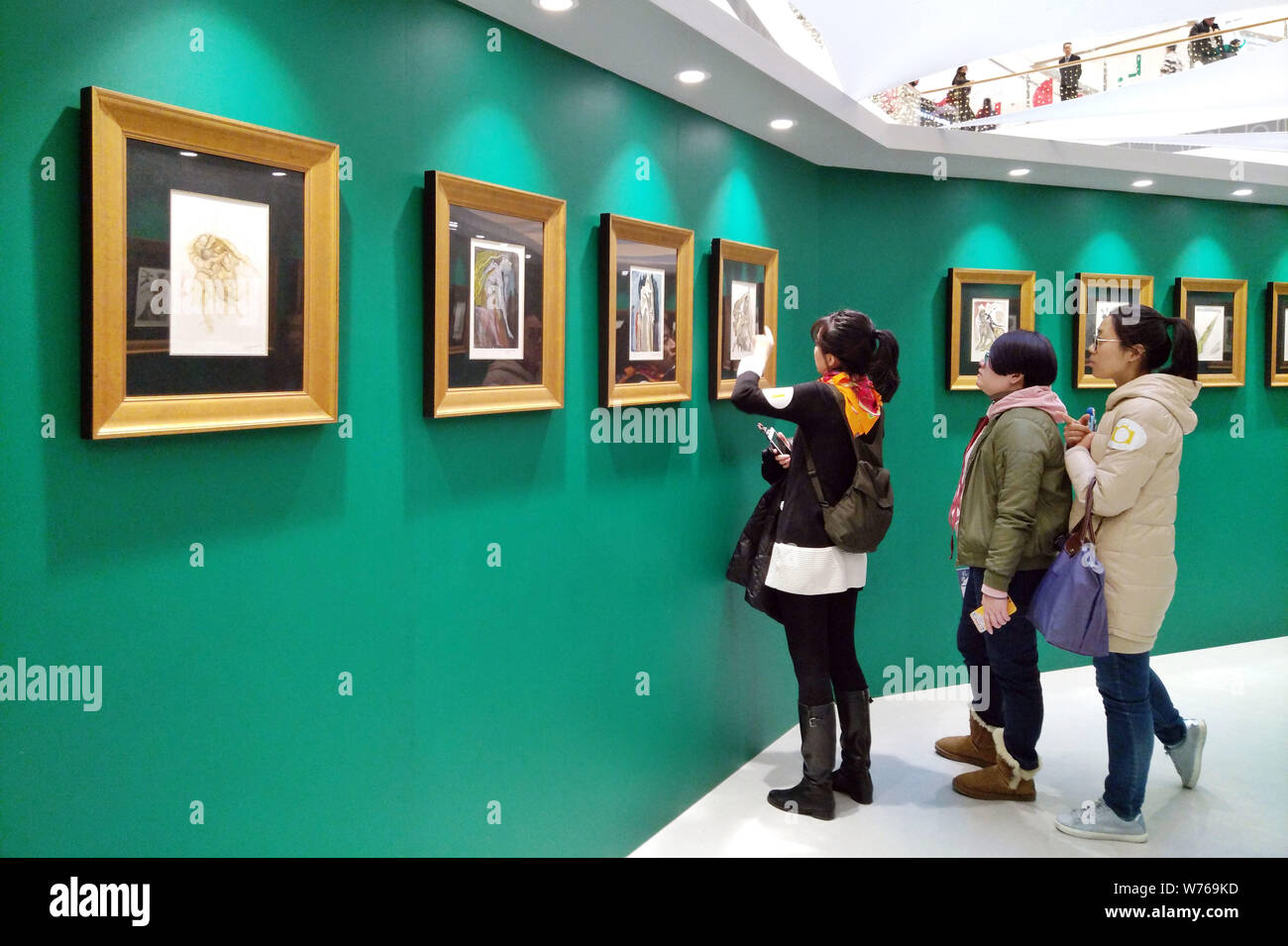 Visitors look at woodblock pieces by Spanish surrealist artist Salvador ...