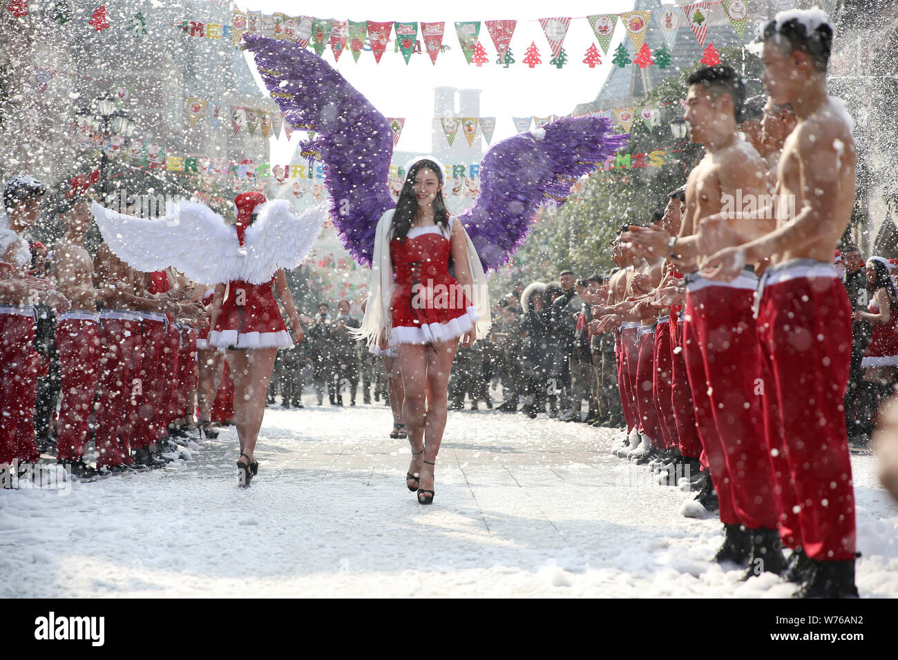 College students dressed in Santa Claus costumes take part in a ...