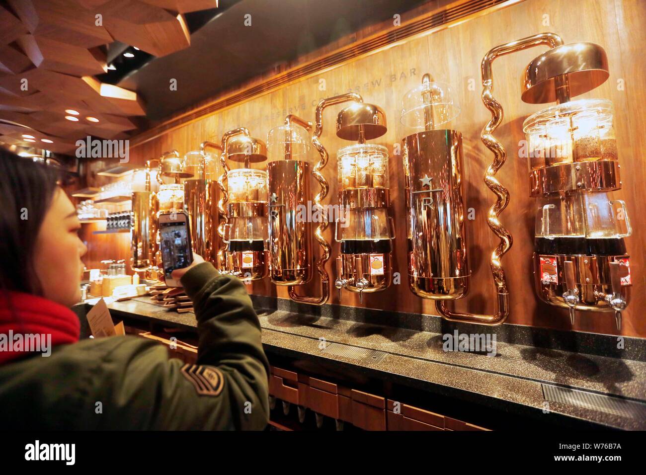 A customer takes photos of coffee devices at a coffee bar of the world ...