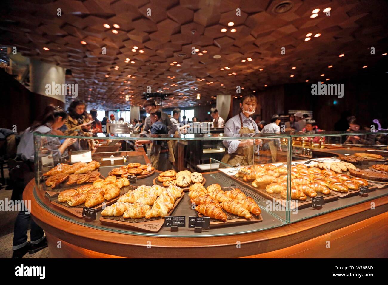 Employees sell breads at the bakery of the world's largest Starbucks ...
