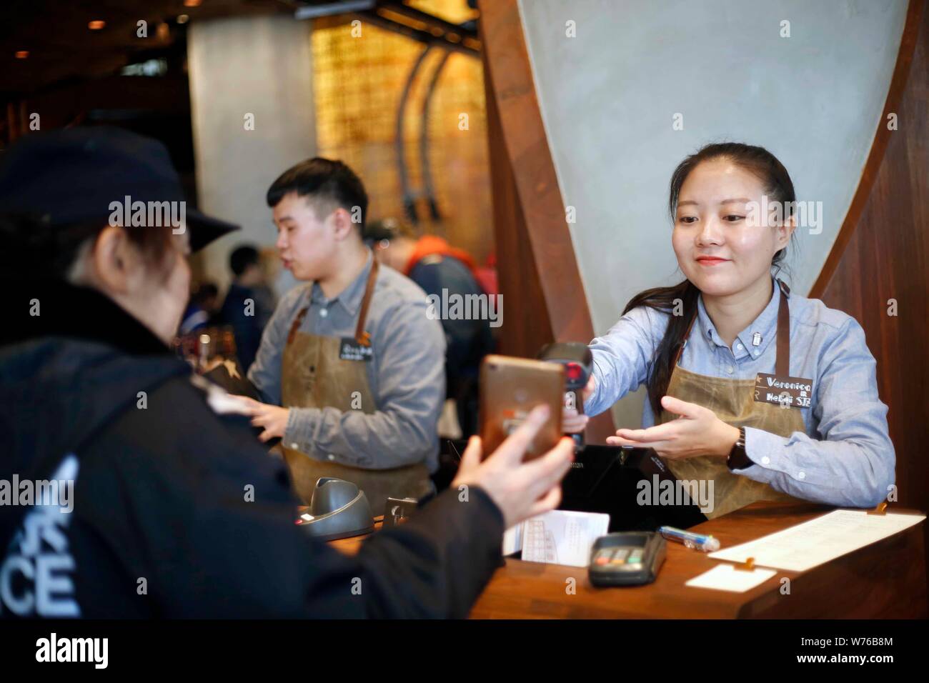 A Chinese employee scans the QR code through mobile payment service ...