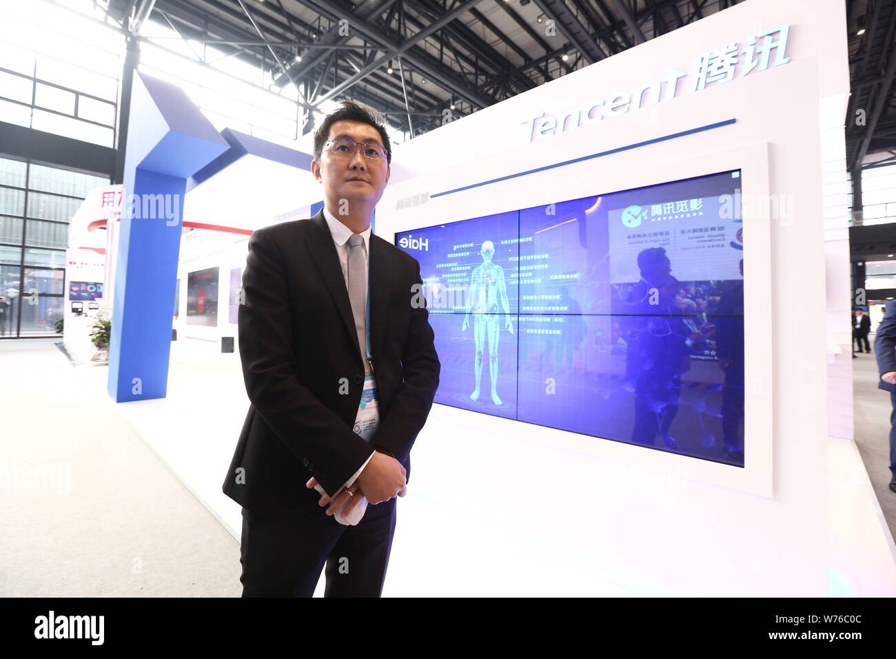 Pony Ma Huateng, Chairman and CEO of Tencent Holdings Ltd., poses for photos at the stand of ...