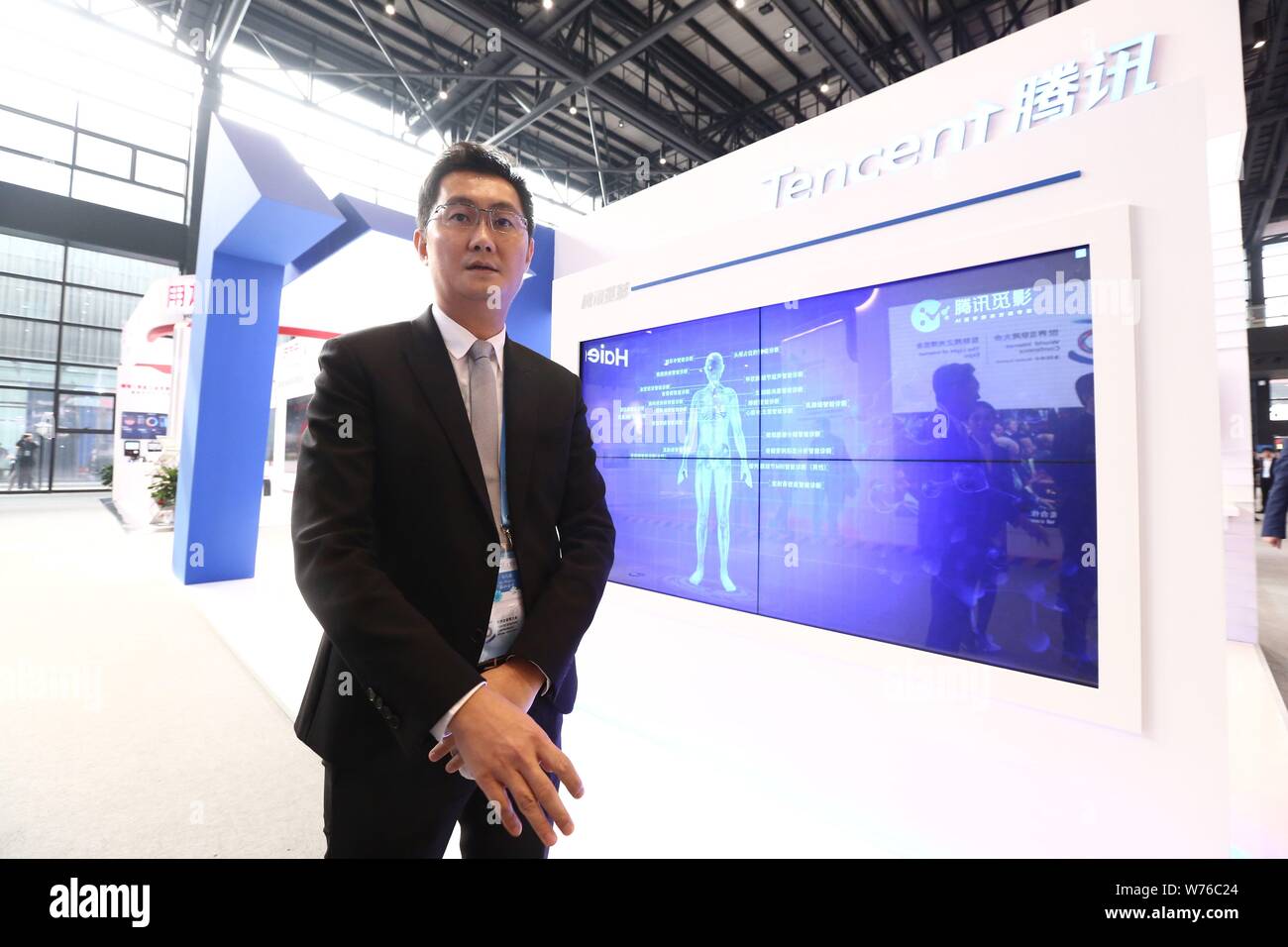 Pony Ma Huateng, Chairman and CEO of Tencent Holdings Ltd., poses for photos at the stand of ...