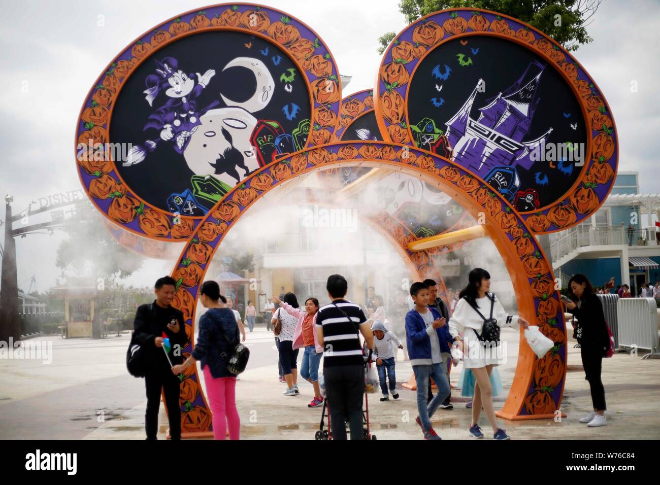 --FILE--Tourists enjoy water vapor being sprayed to cool them off at a ...