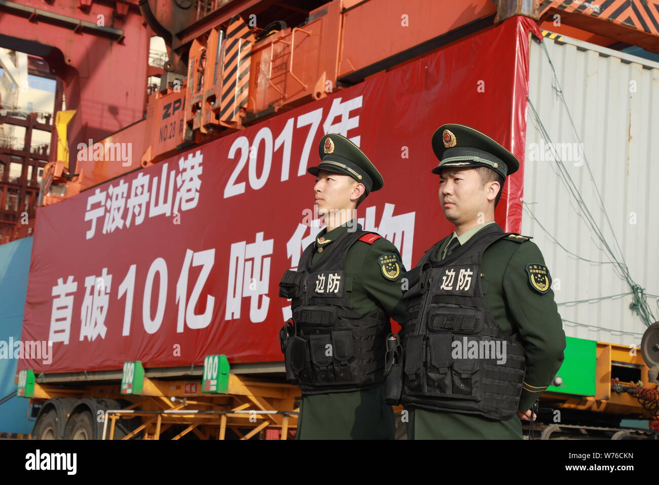 Chinese border police officers stand guard in front of a truck carrying ...