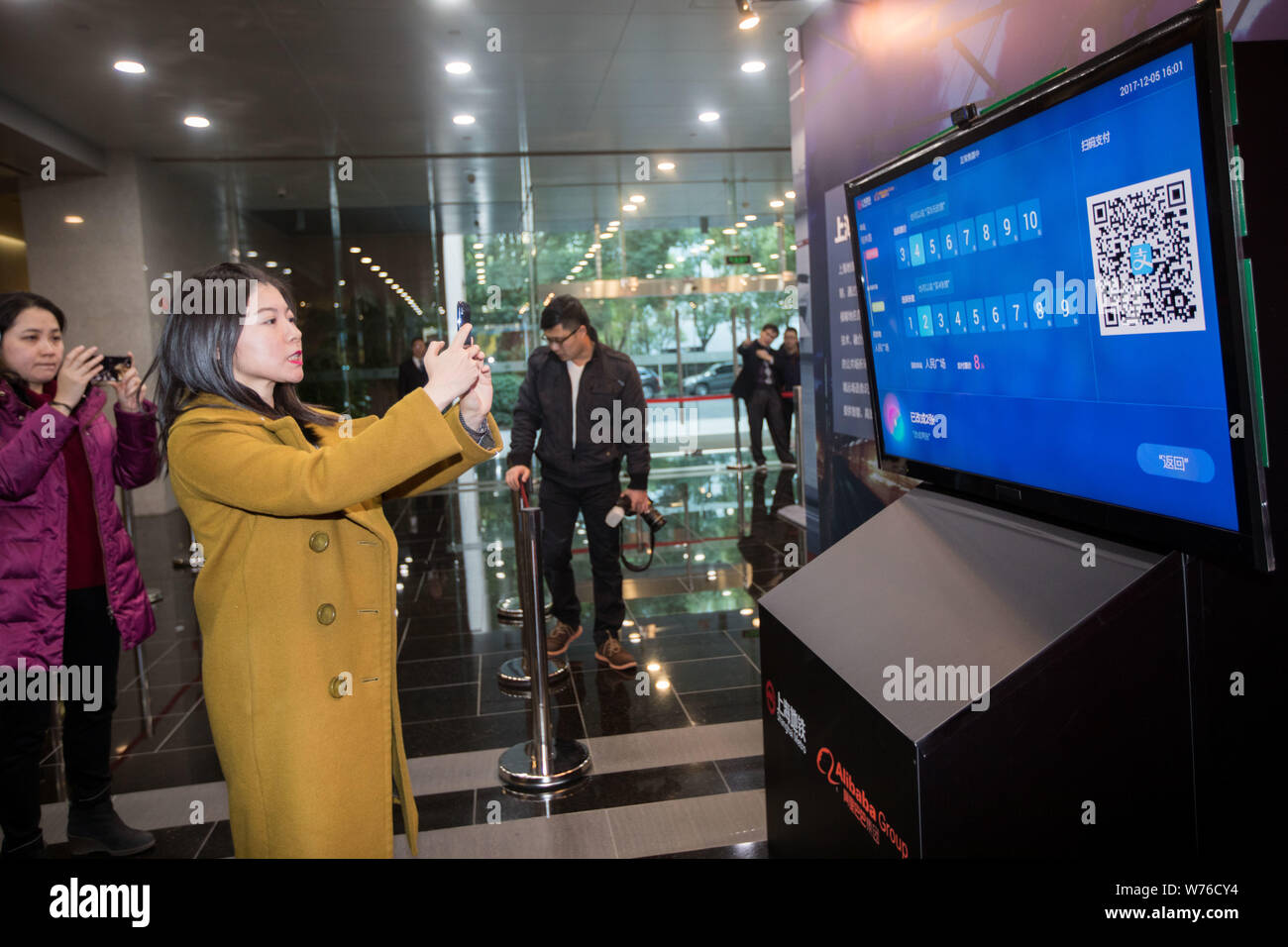 A visitor uses mobile payment service Alipay on her smartphone to scan ...