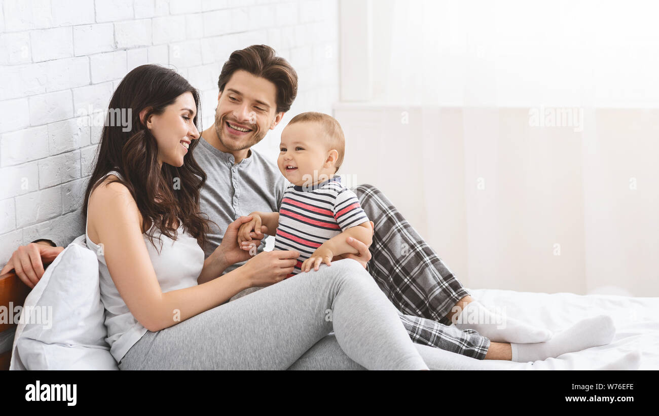 Happy millennial couple enjoying parenthood with adorable baby Stock ...