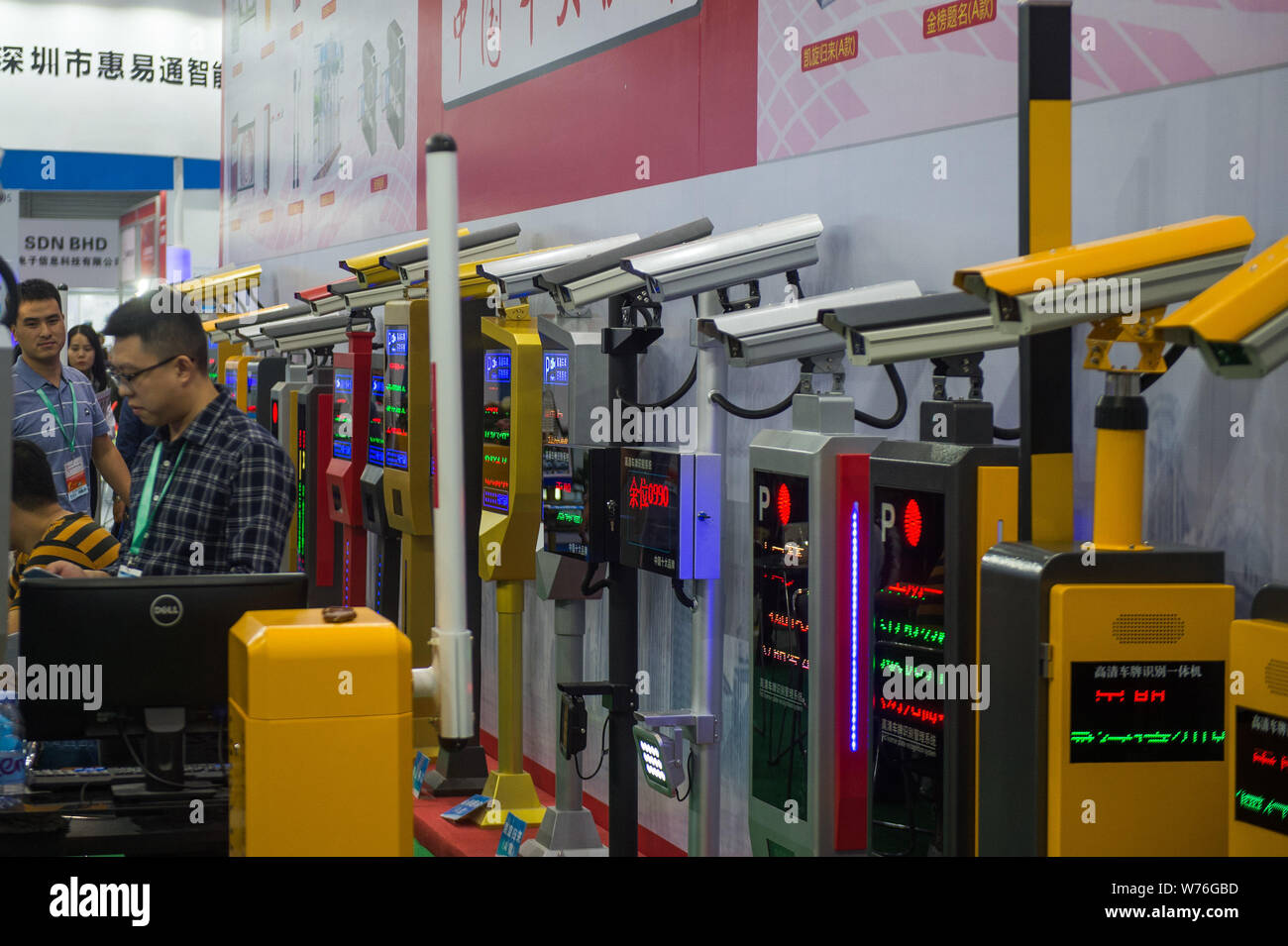 Visitors look at surveillance cameras on display during the 16th China ...