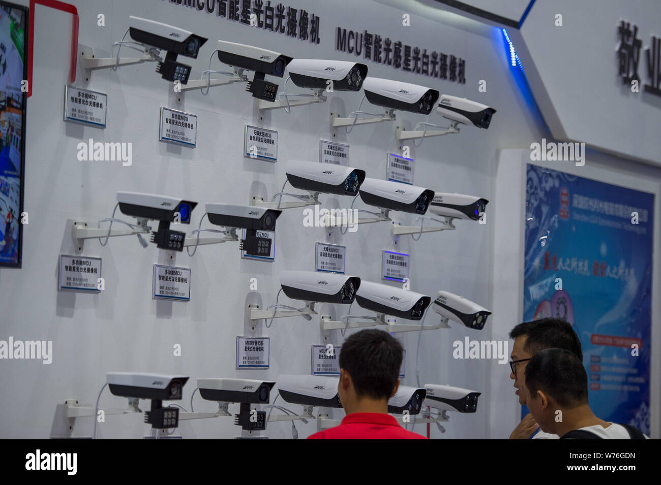 Visitors look at surveillance cameras on display during the 16th China ...
