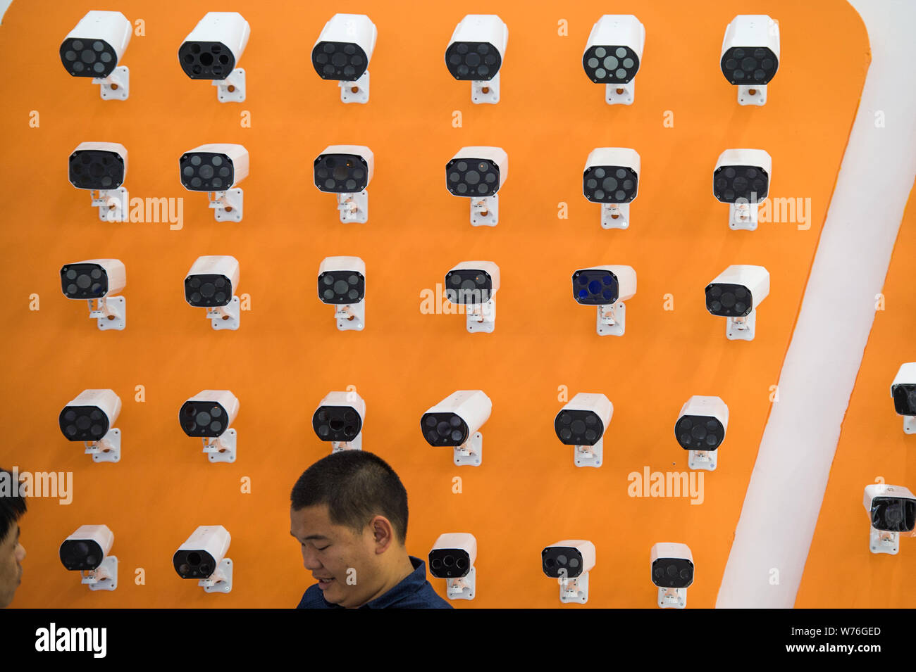 A visitor is pictured in front of surveillance cameras on display ...