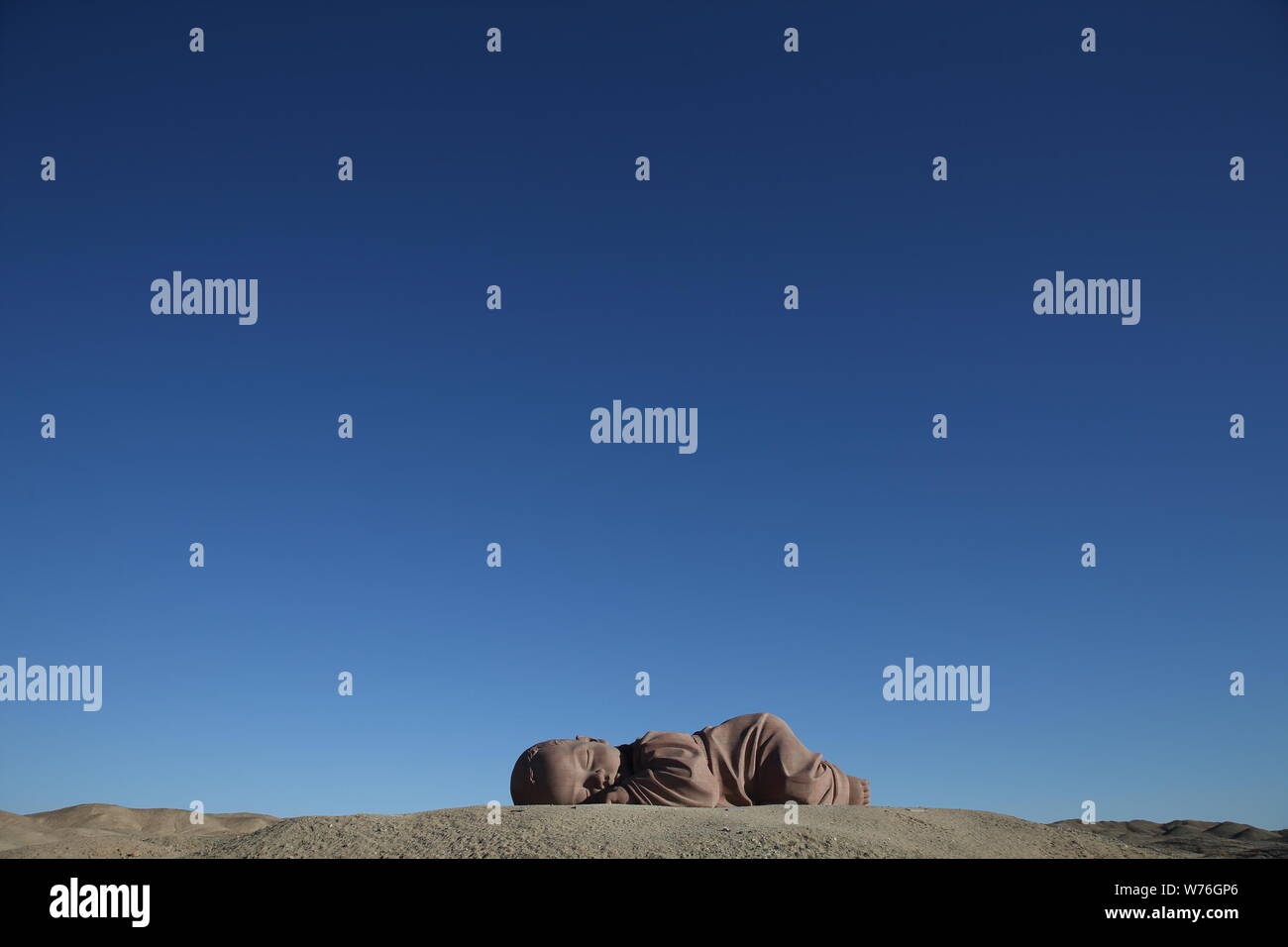 A giant 3D sleeping baby sculpture is on display on the Gobi Desert in ...
