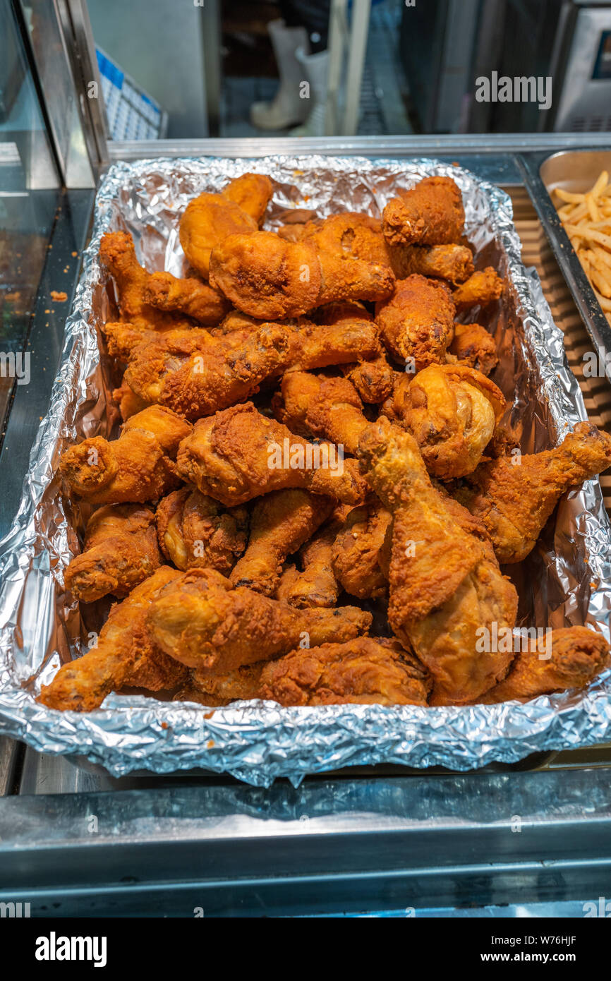 Vertical photo of pile of fried chicken drumsticks at market Stock ...