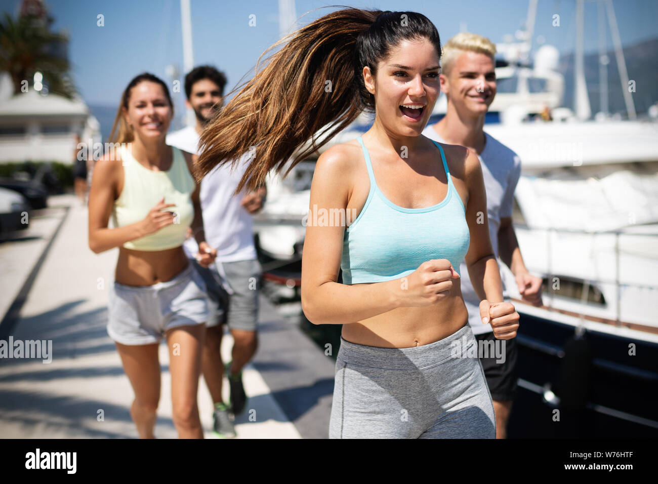 Happy fit people running and jogging together in summer sunny nature ...