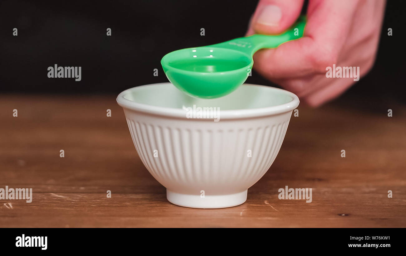 Step by step. Measuring olive oil with a tablespoon Stock Photo - Alamy