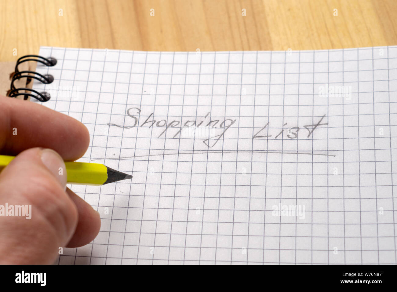 A man writes in yellow pencil in a notebook. Sign Shopping List Stock ...