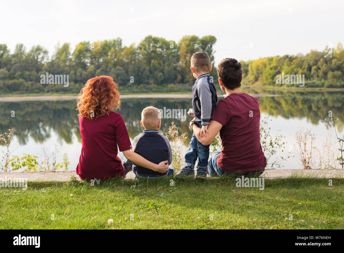 Parenthood, nature, people concept - family with two sons sitting near ...
