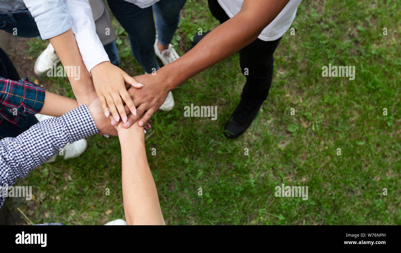 Unity and teamwork. College students putting hands together Stock Photo ...