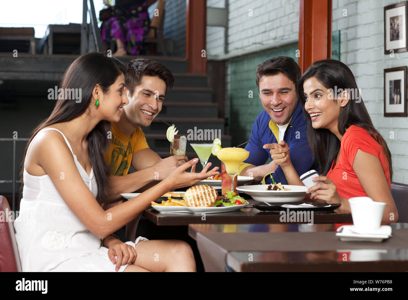 Indian friends having dinner in a restaurant Stock Photo - Alamy