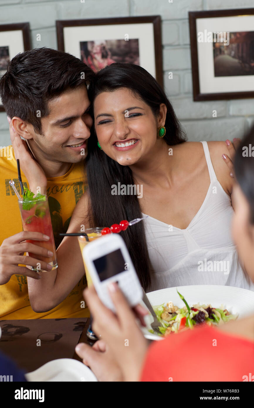 Indian woman talking a picture of a couple with a mobile phone in a ...