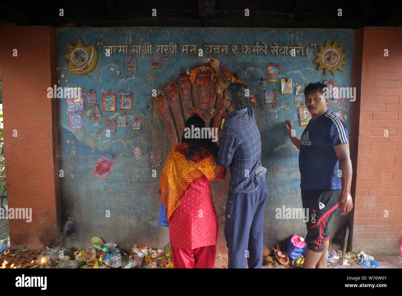 Devotees worship an idol of snake god at the Nagpokhari during a ...