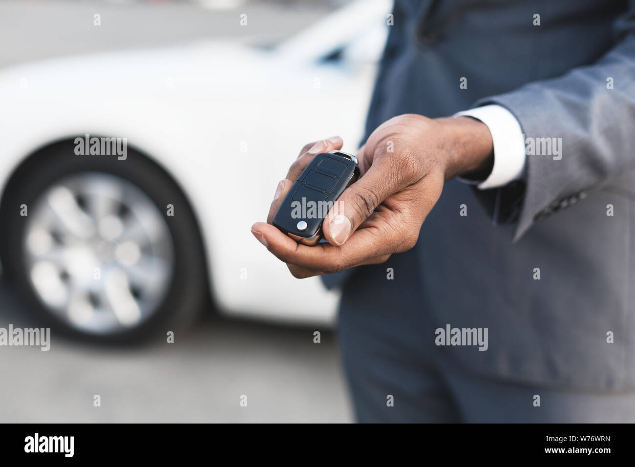 Car rental concept. Young man showing key of his new car Stock Photo ...