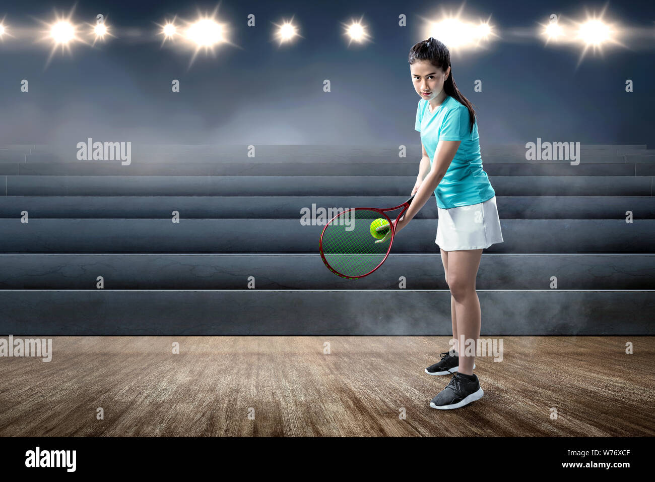 Asian woman with a tennis racket and ball in her hands ready in serve ...