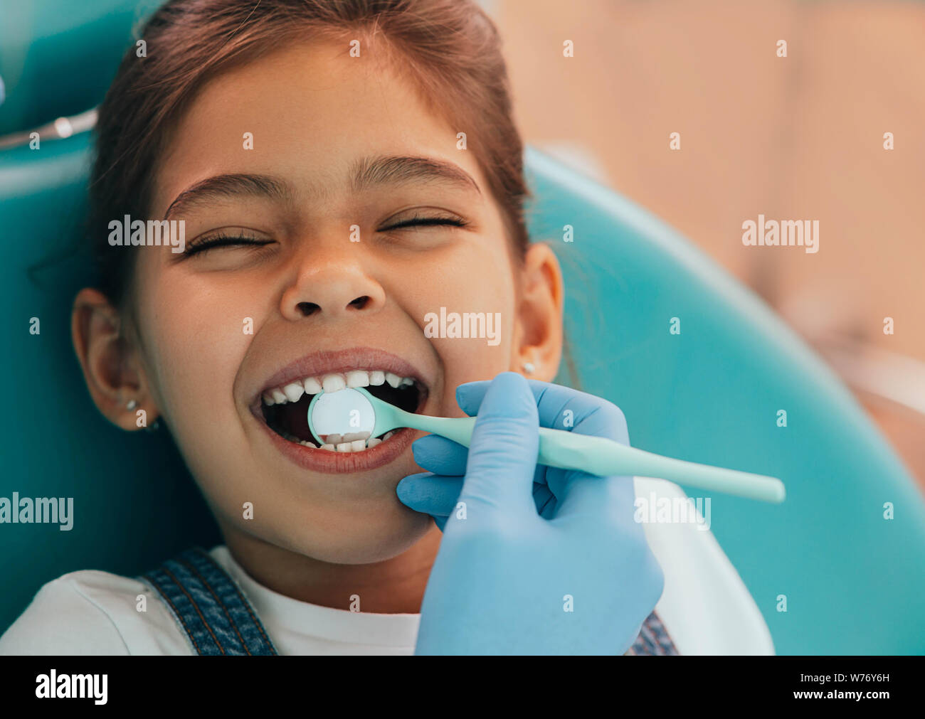 Cute little girl getting teeth exam at dental clinic Stock Photo - Alamy