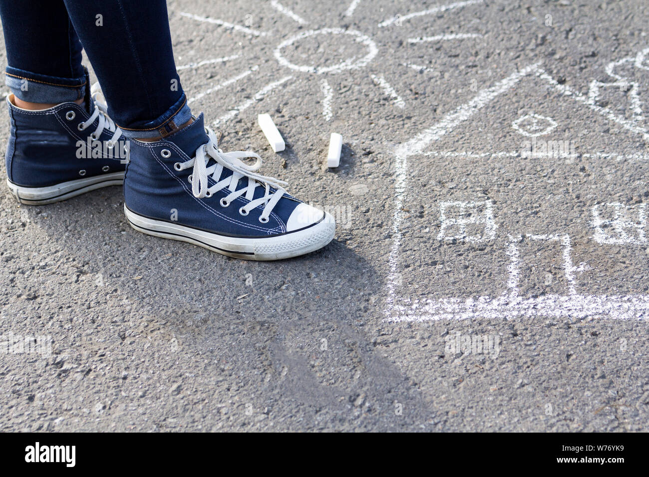 Feet girl in sneakers cost about drawing a chalk on the pavement Stock ...