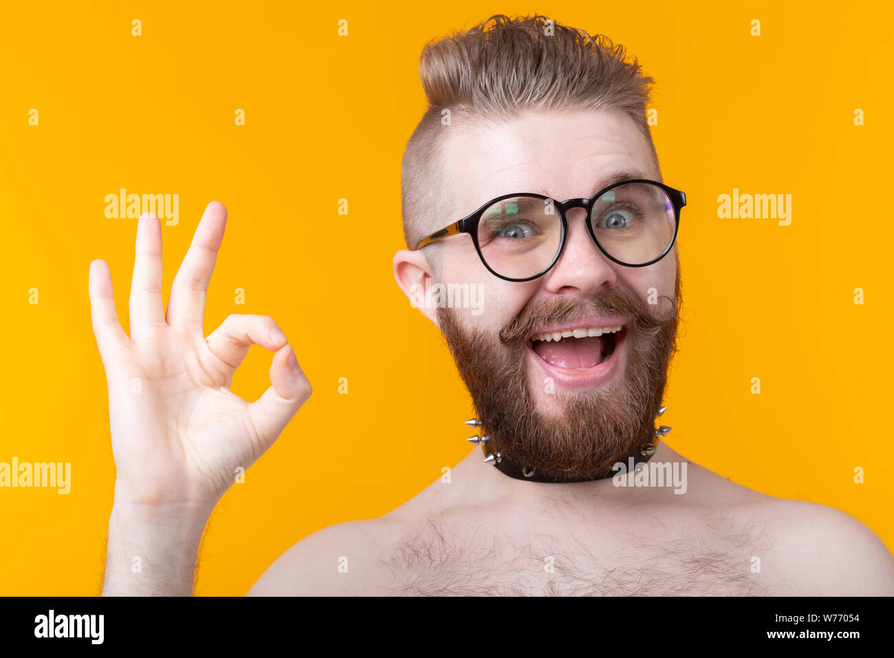 Positive funny hipster shirtless guy with a rocker collar shows ok on a ...