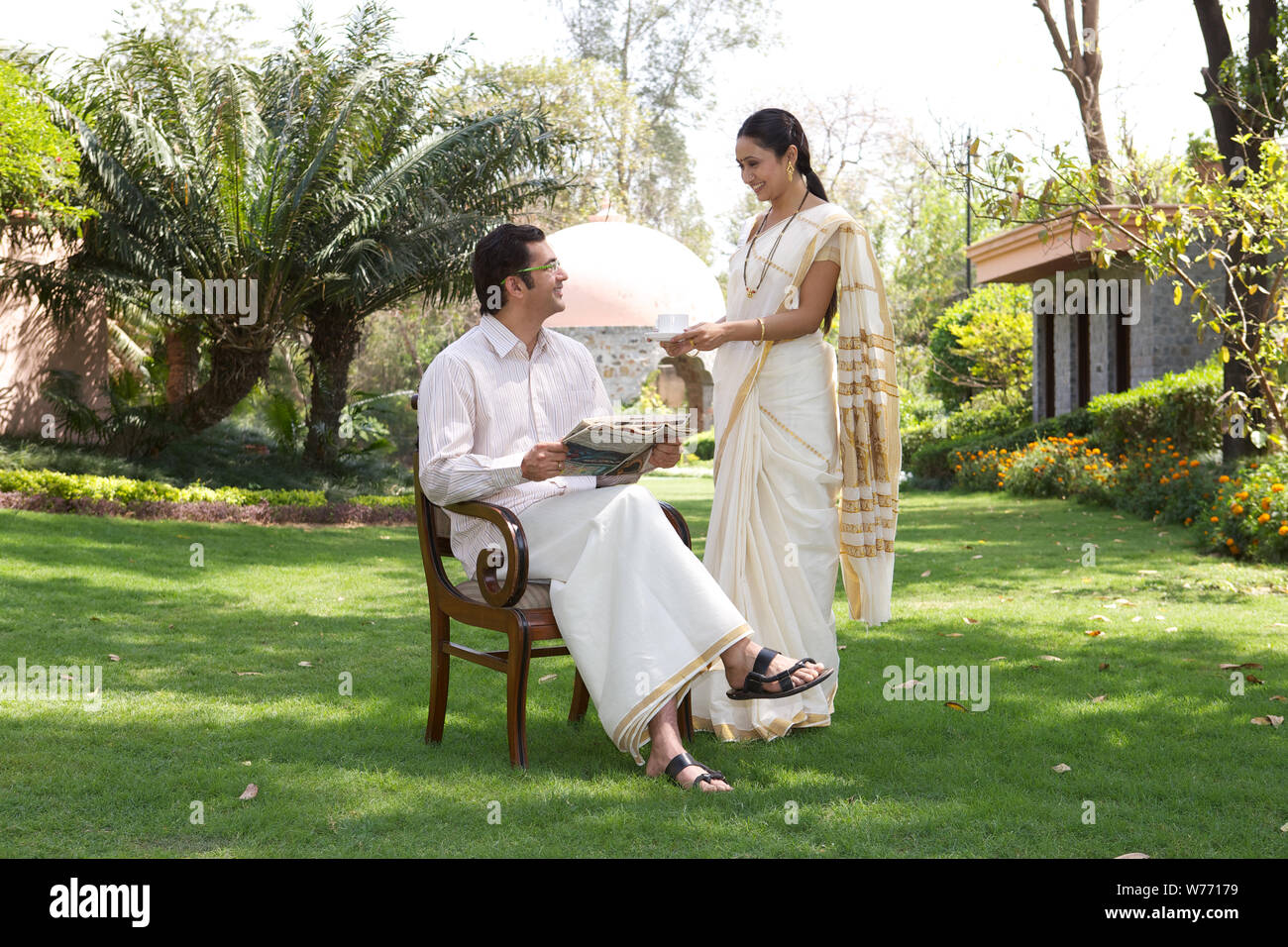Young woman giving a cup of tea to her husband Stock Photo - Alamy