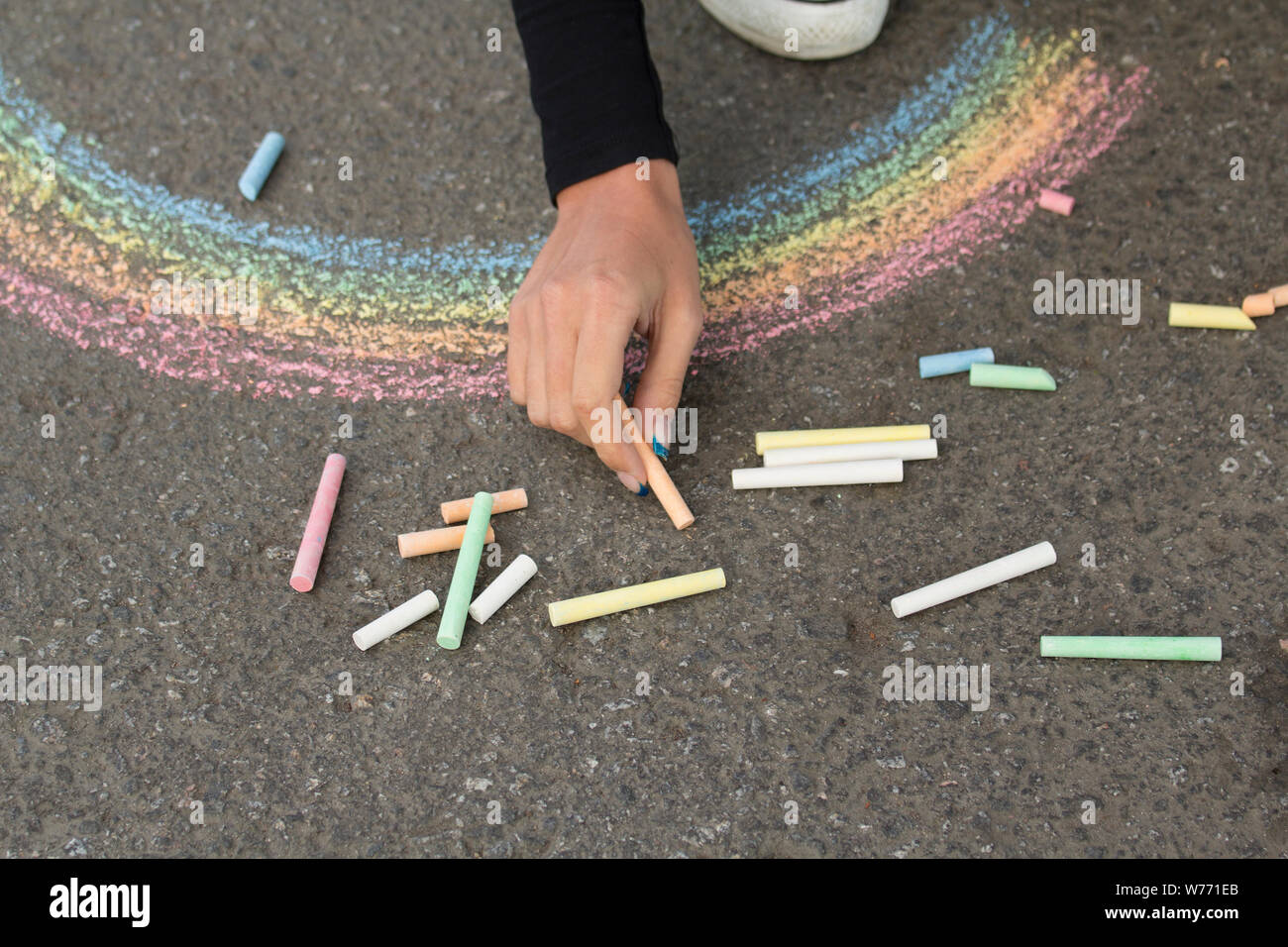 Hand draws with crayons colored Rainbow girl on the pavement Stock ...