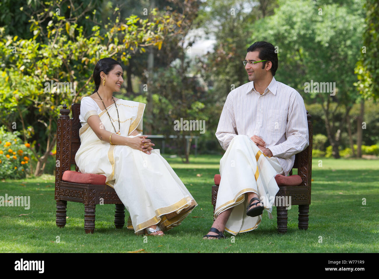 South Indian couple sitting on chairs in a lawn Stock Photo - Alamy