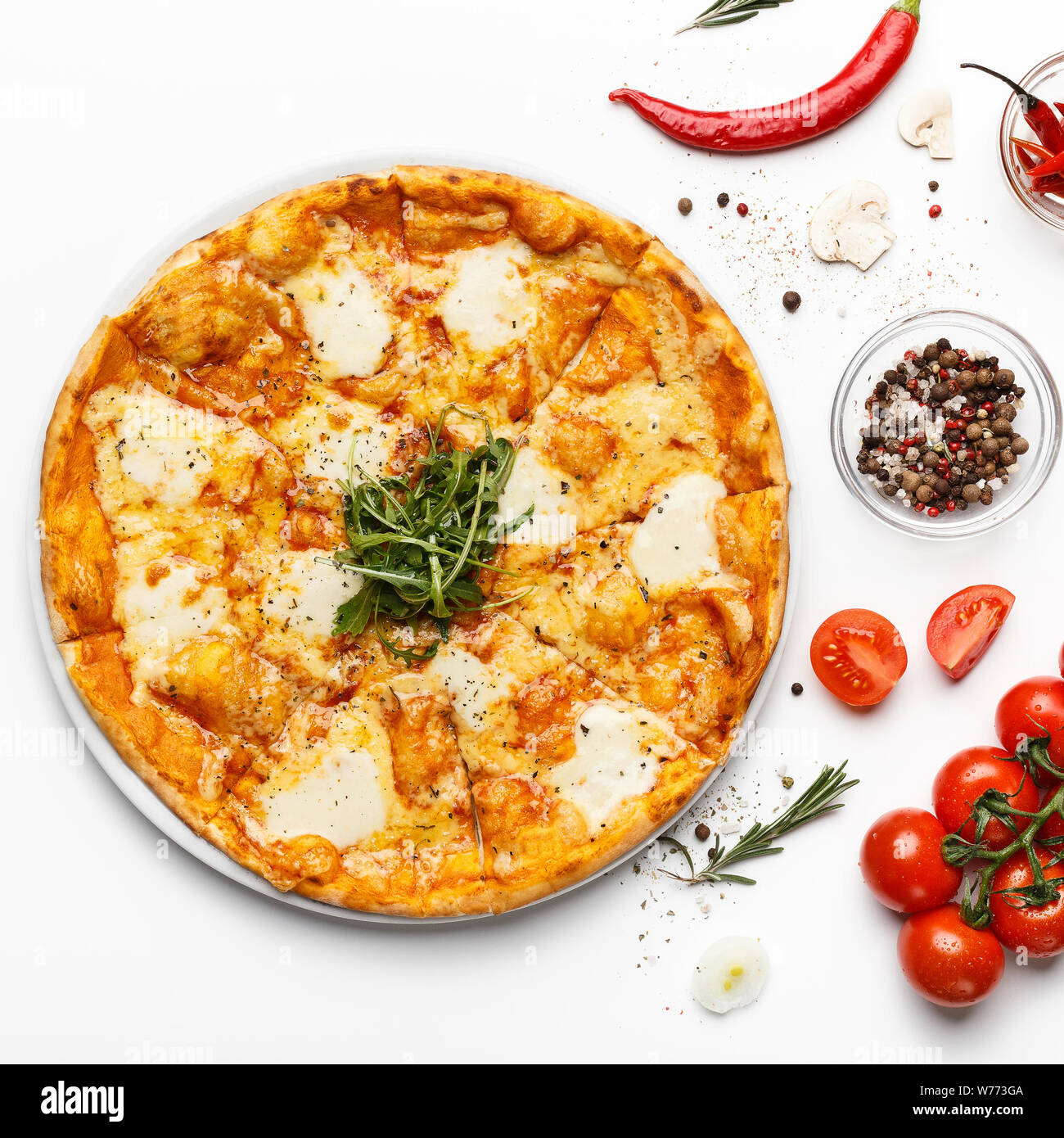 Hot cheesy italian pizza and spices on white table Stock Photo - Alamy
