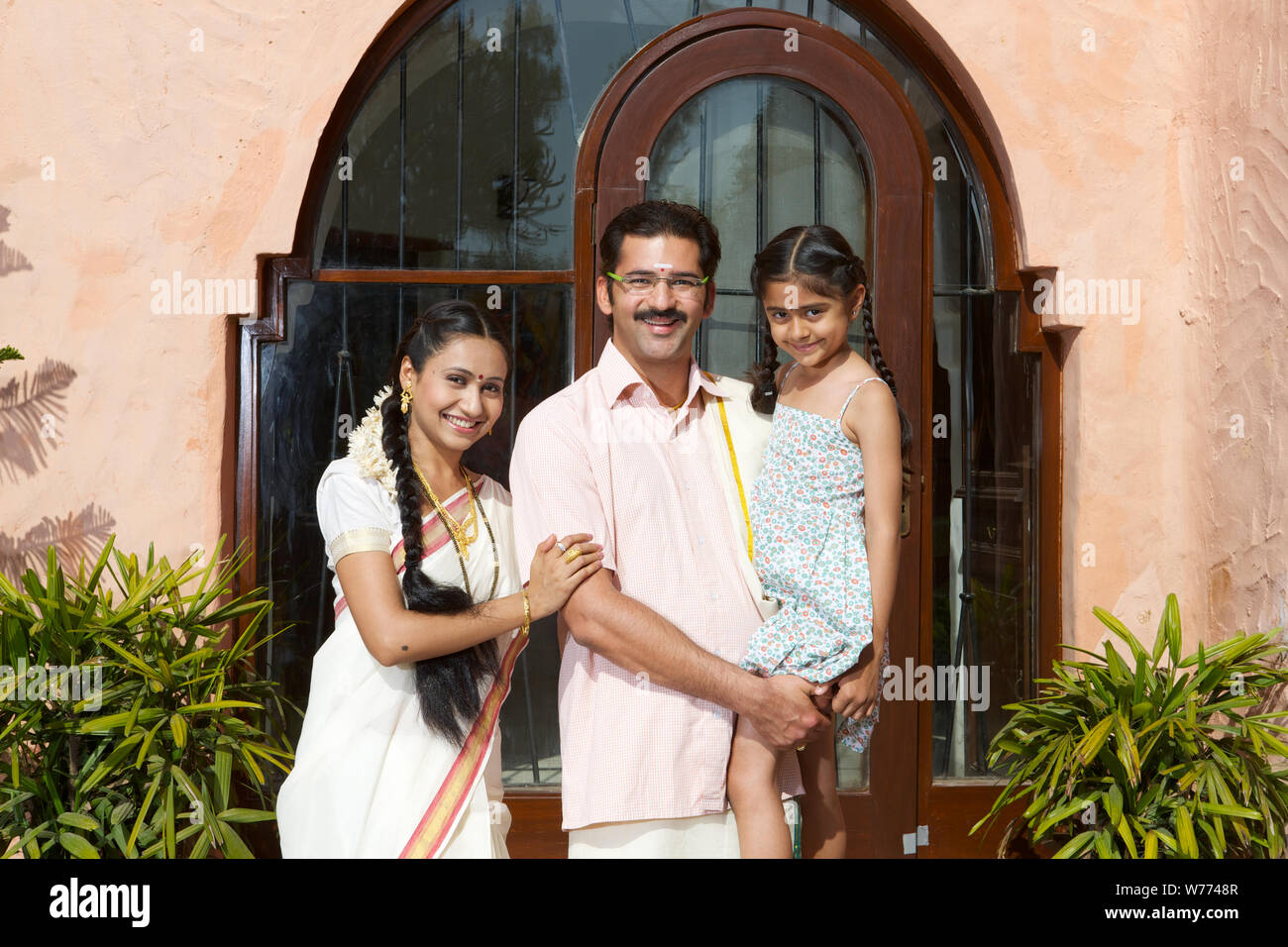 South Indian family standing together in front of house Stock Photo - Alamy
