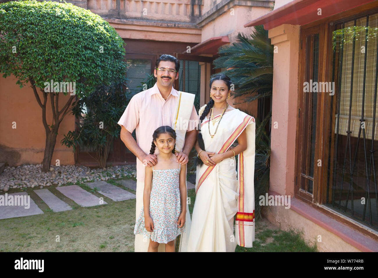 South Indian family standing together in a lawn Stock Photo - Alamy