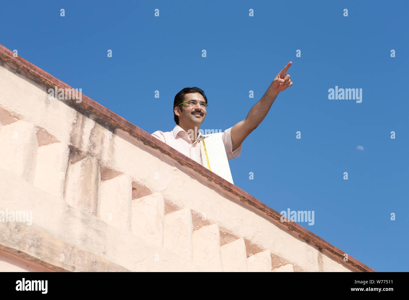 Low angle view of a south Indian man pointing Stock Photo - Alamy
