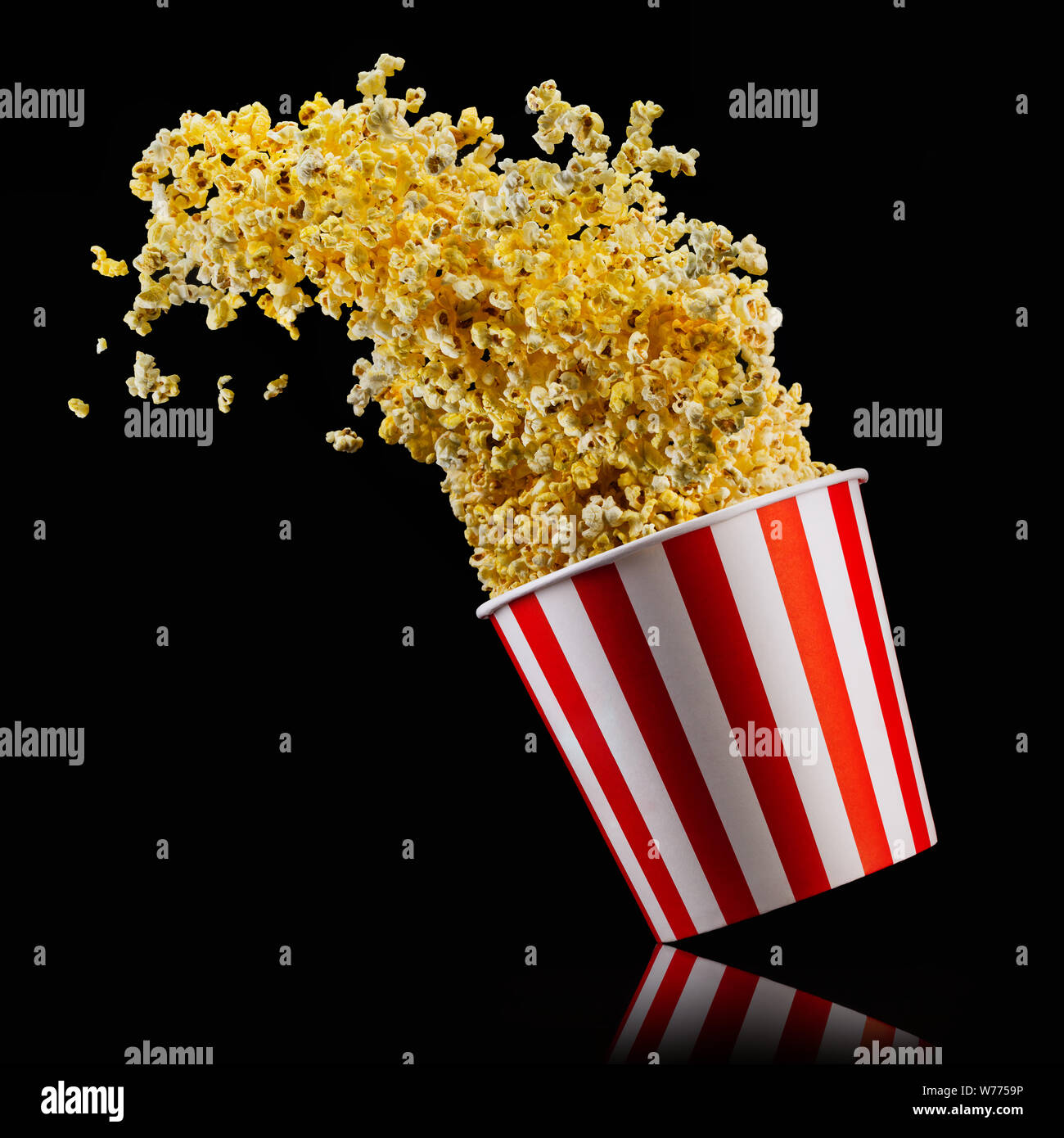 Flying popcorn from striped bucket isolated on black background Stock ...