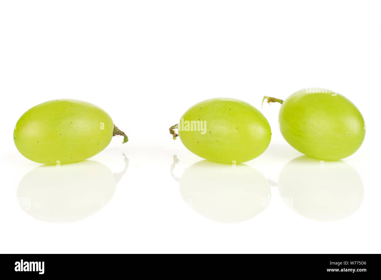 Group of three whole fresh green grape in row isolated on white ...
