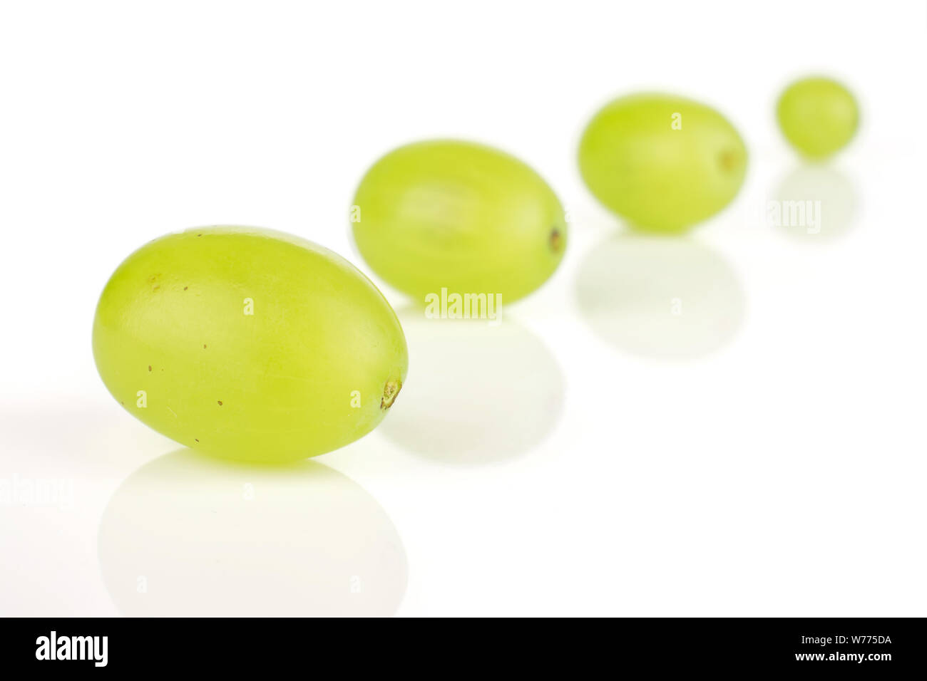 Group of four whole fresh green grape placed diagonally in line ...