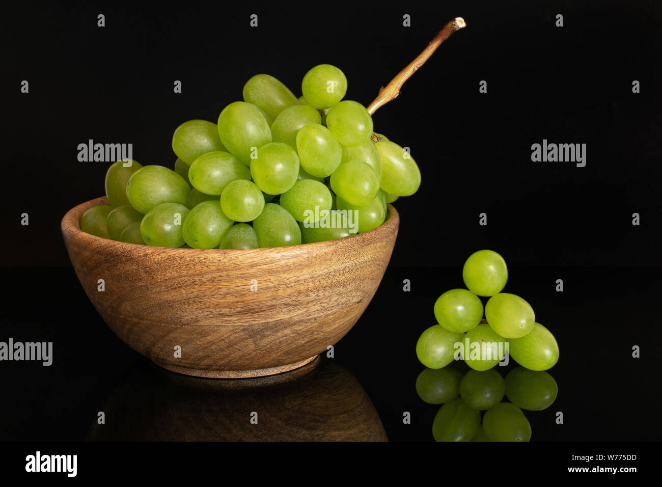 Lot of whole fresh green grape in big wooden bowl arranged in pyramid ...