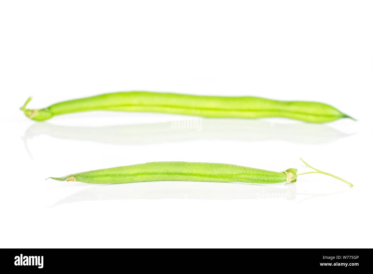 Group of two whole fresh green bean one is above of the other isolated ...