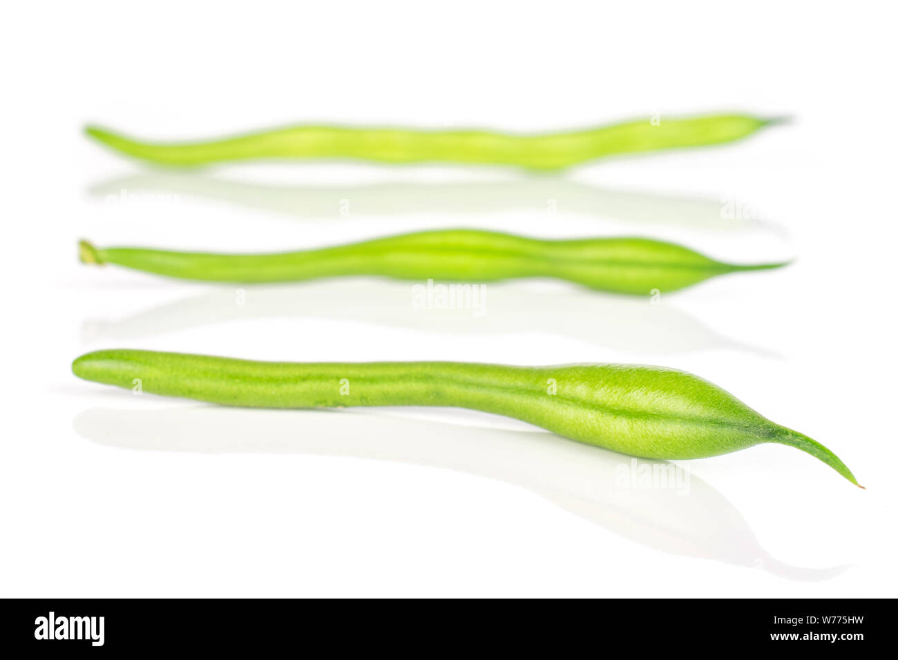 Group of three whole fresh green bean in row isolated on white ...