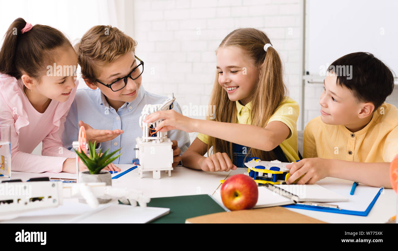 Happy children constructing robotic device at stem class Stock Photo ...