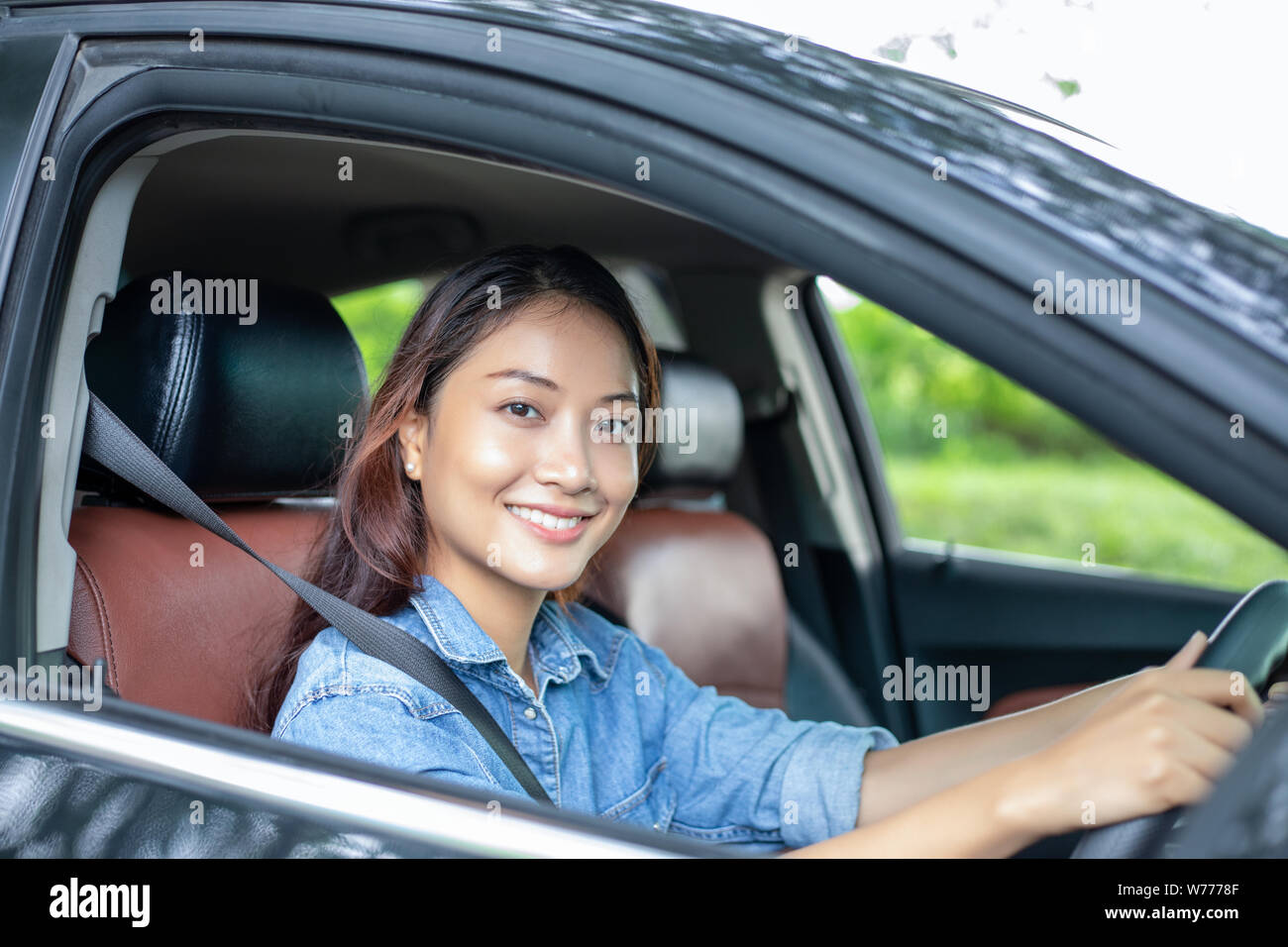 Beautiful Asian woman smiling and enjoying.driving a car on road for ...
